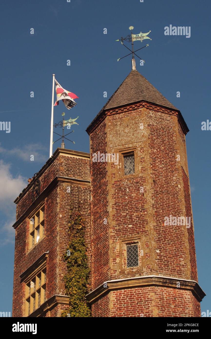 Castle tower with lattice windows, flagpole and weather veins against a ...