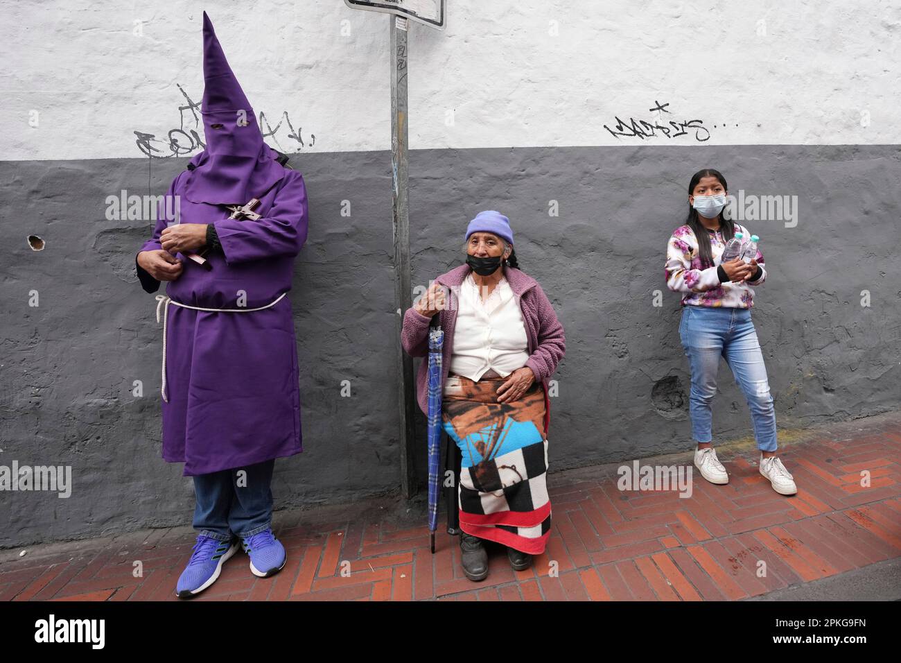 A Catholic penitent known as a "Cucurucho" take a break during the ...