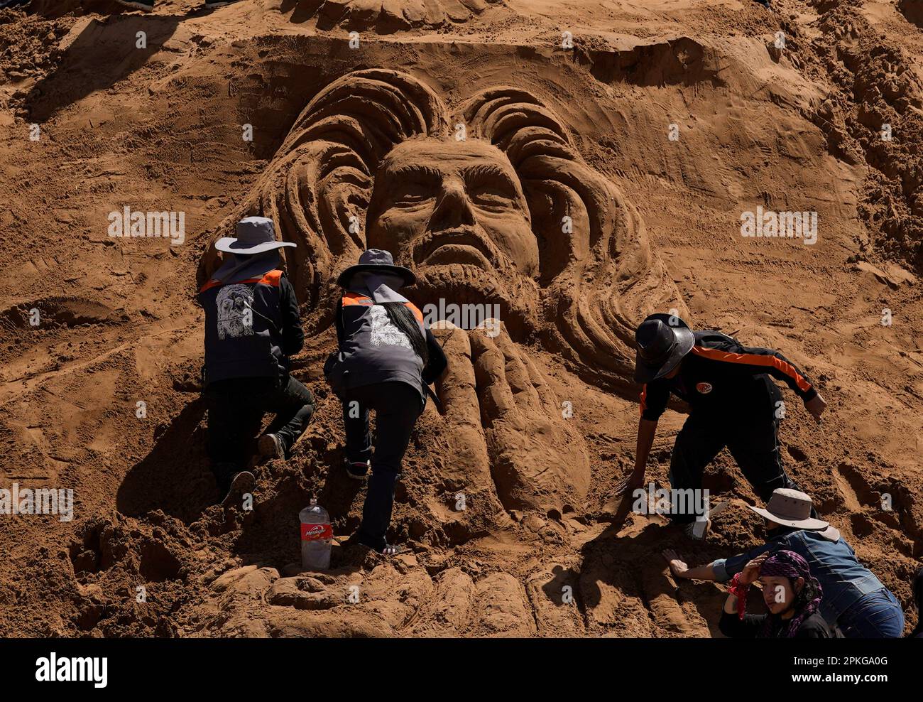 Artists work on a sand sculpture depicting Jesus Christ, as part of ...