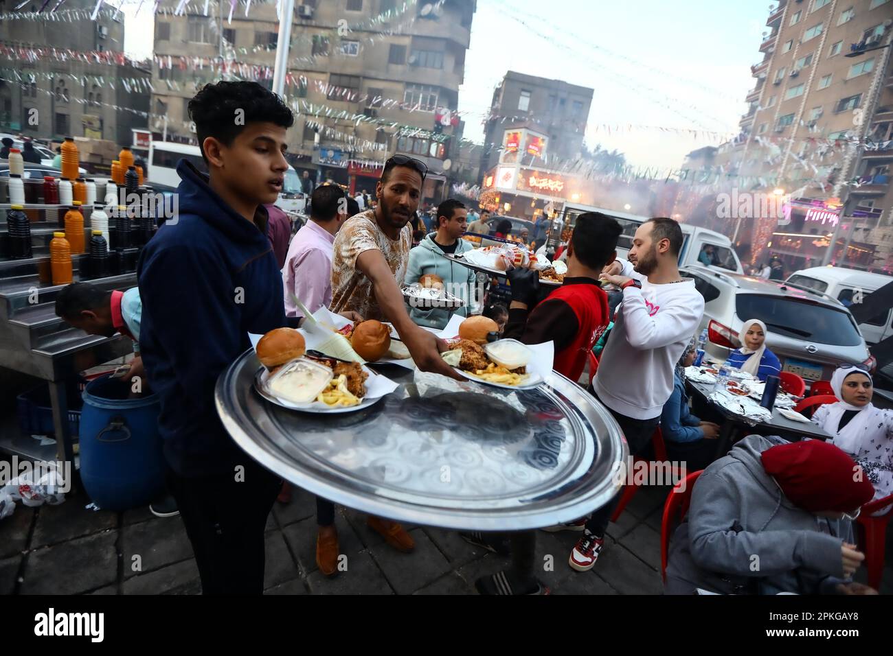 Cairo, Egypt. 7th Apr, 2023. A man serves iftar meals to people during Ramadan in Cairo, Egypt ...