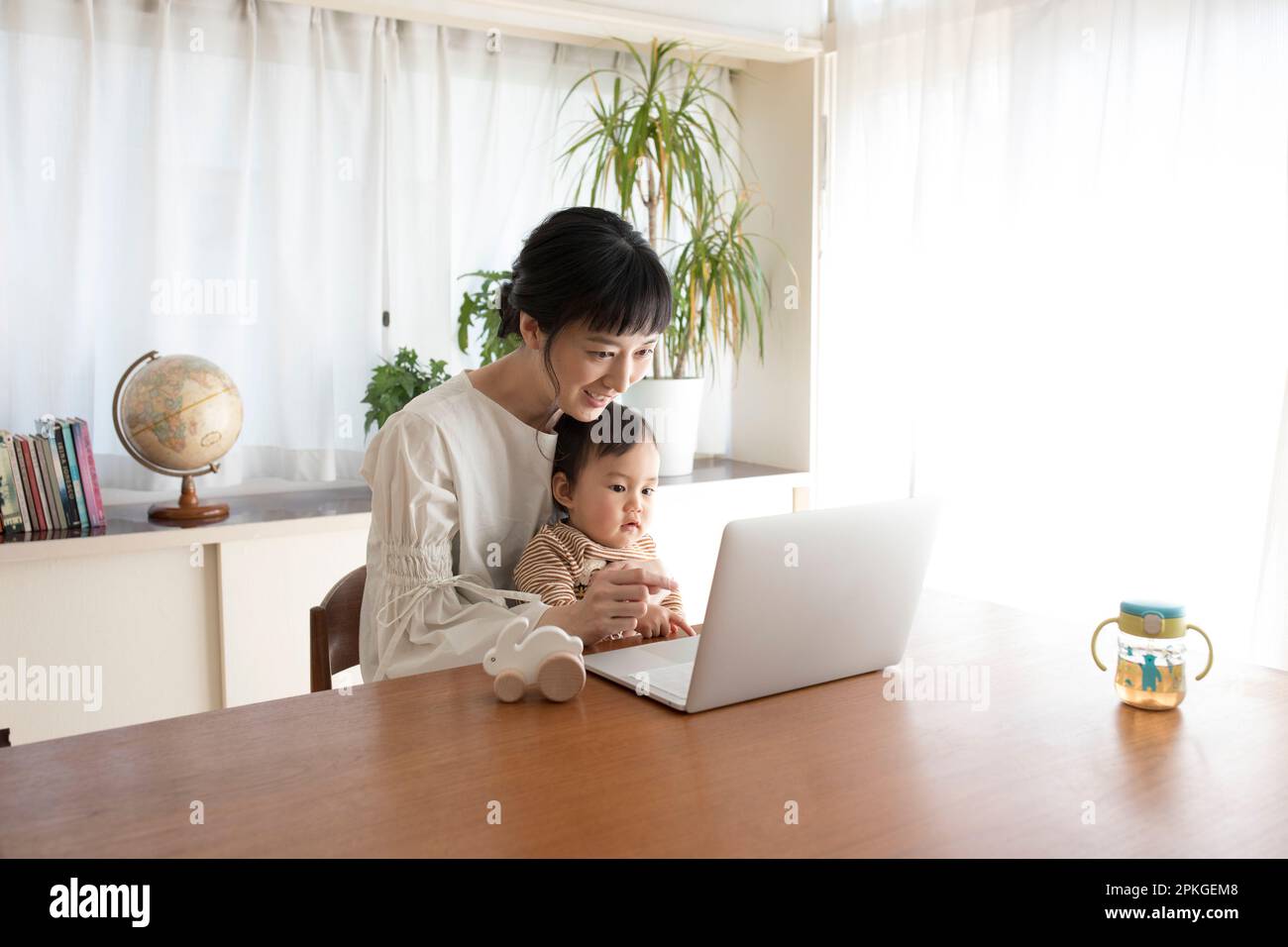 Baby and Mother Watching Computer Together in Living Room Stock Photo ...