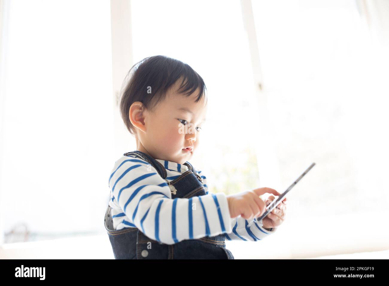 Baby fiddling with the phone Stock Photo - Alamy