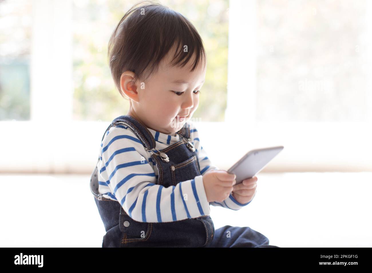 Baby fiddling with the phone Stock Photo - Alamy
