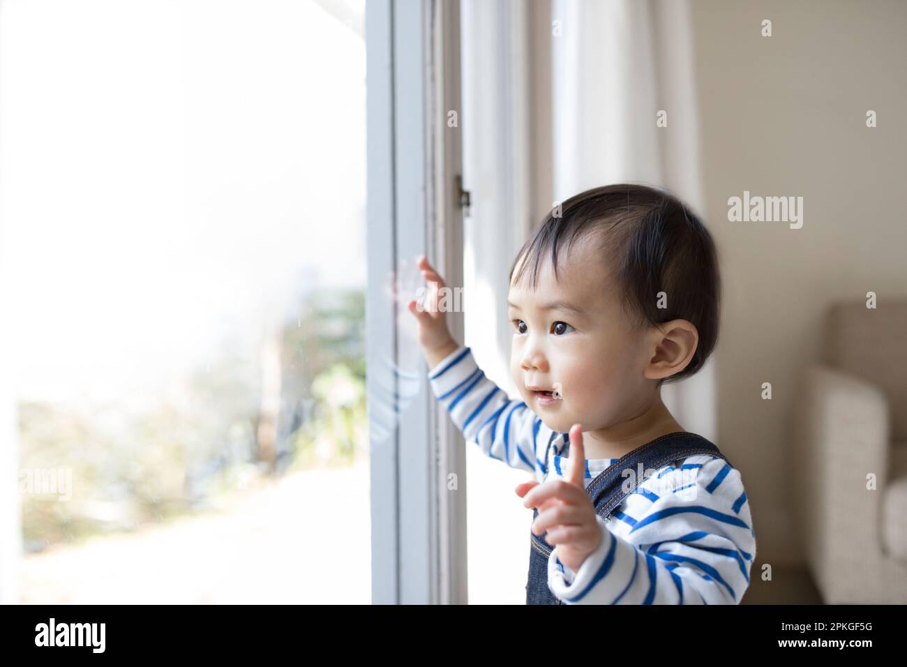 Baby looking outside Stock Photo - Alamy
