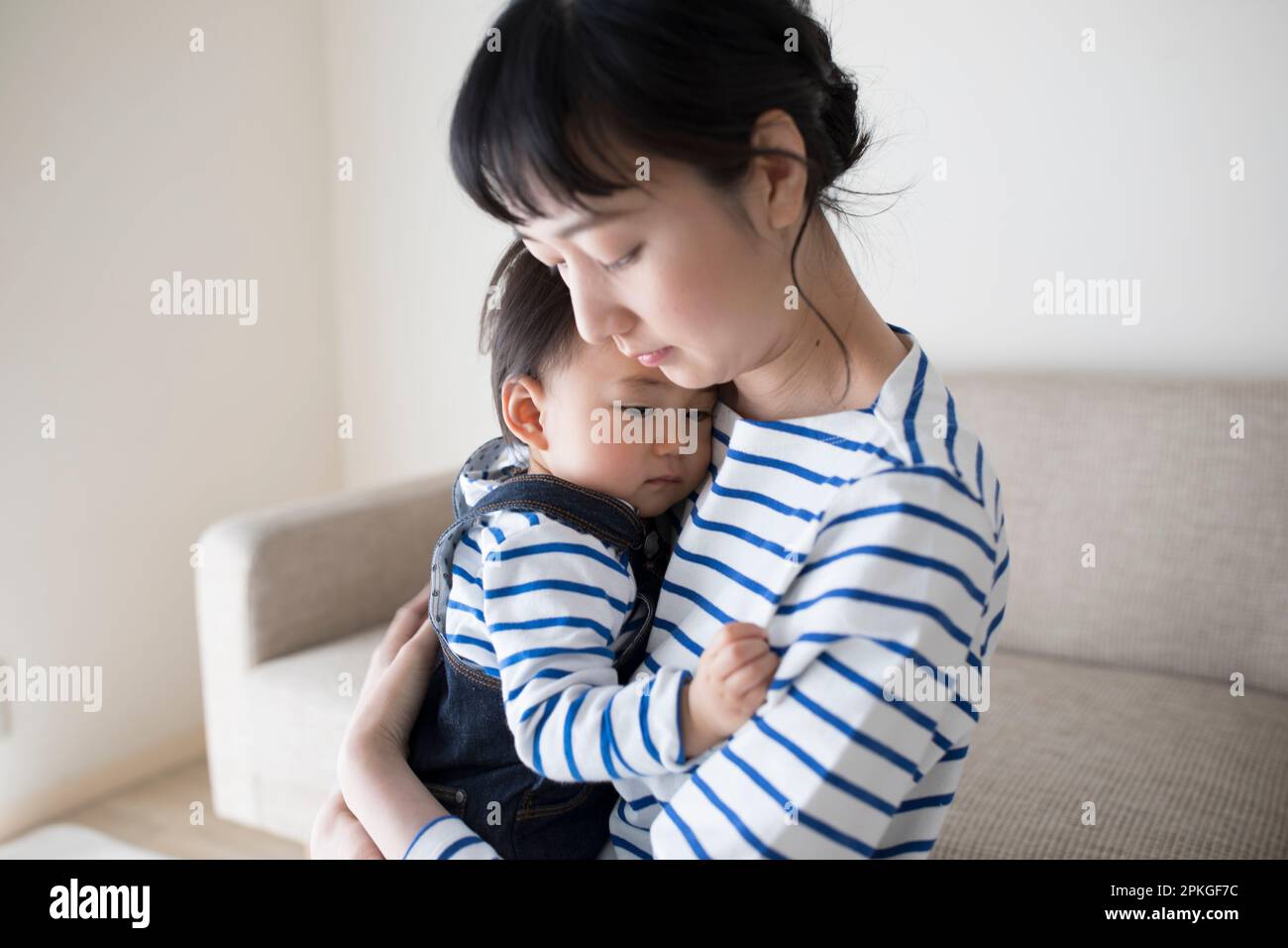 Baby being carried by mother Stock Photo - Alamy
