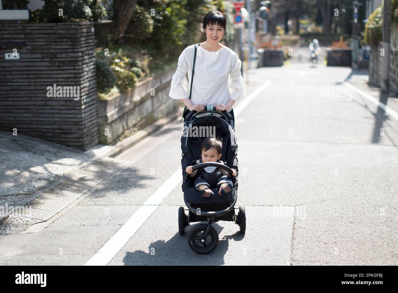 Mother walking with baby in stroller Stock Photo - Alamy