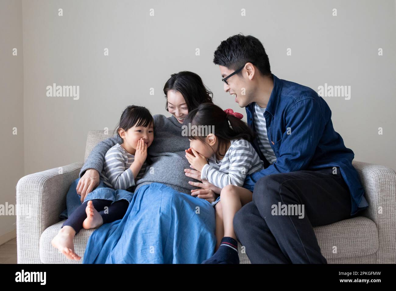 Sisters and father talking to pregnant mother's belly Stock Photo - Alamy