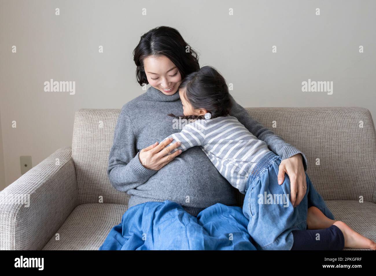 Girl hugging her pregnant mother Stock Photo - Alamy
