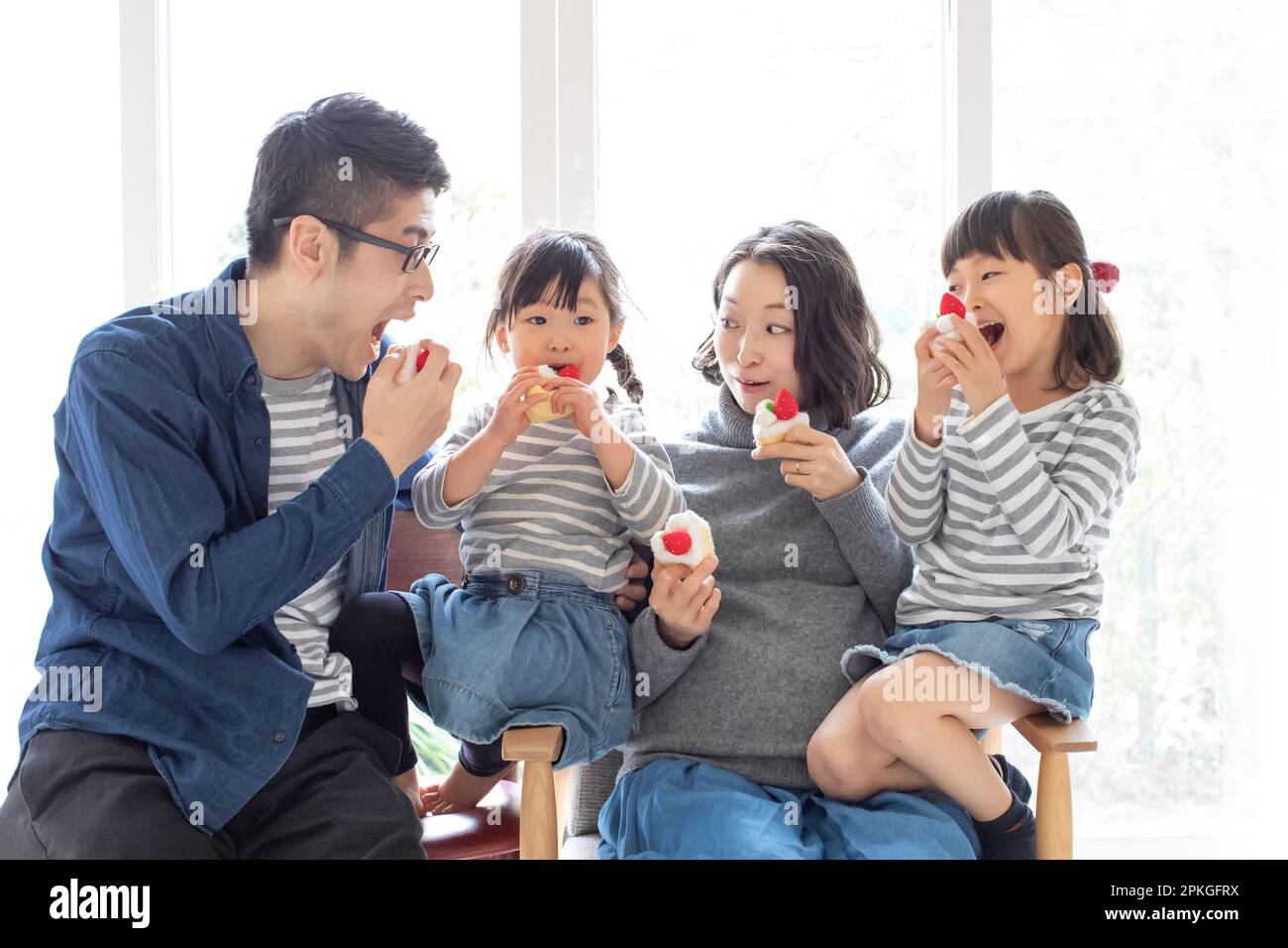 Family pretending to eat a cake toy Stock Photo - Alamy