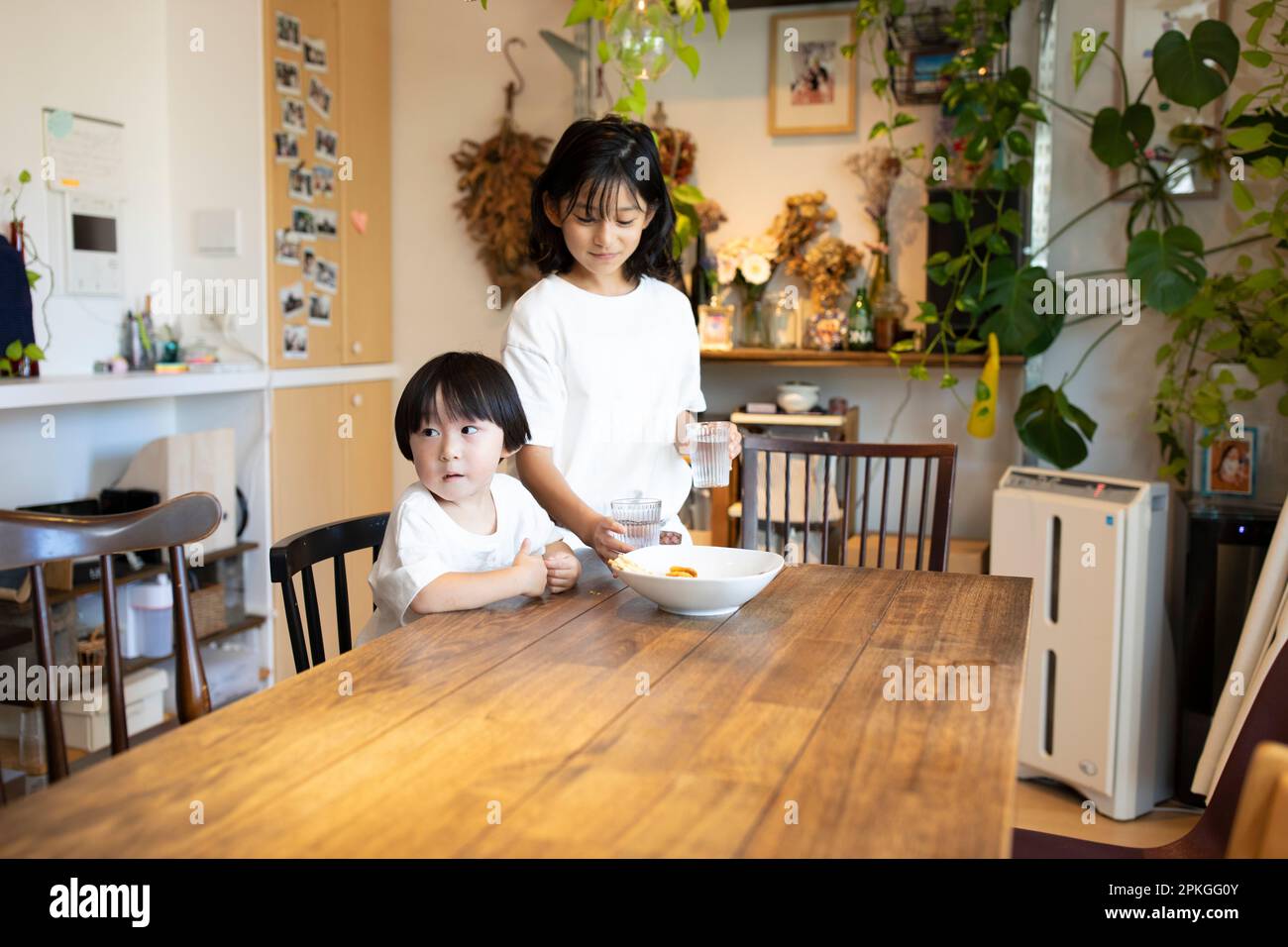 Older sister carrying snacks to younger brother Stock Photo - Alamy
