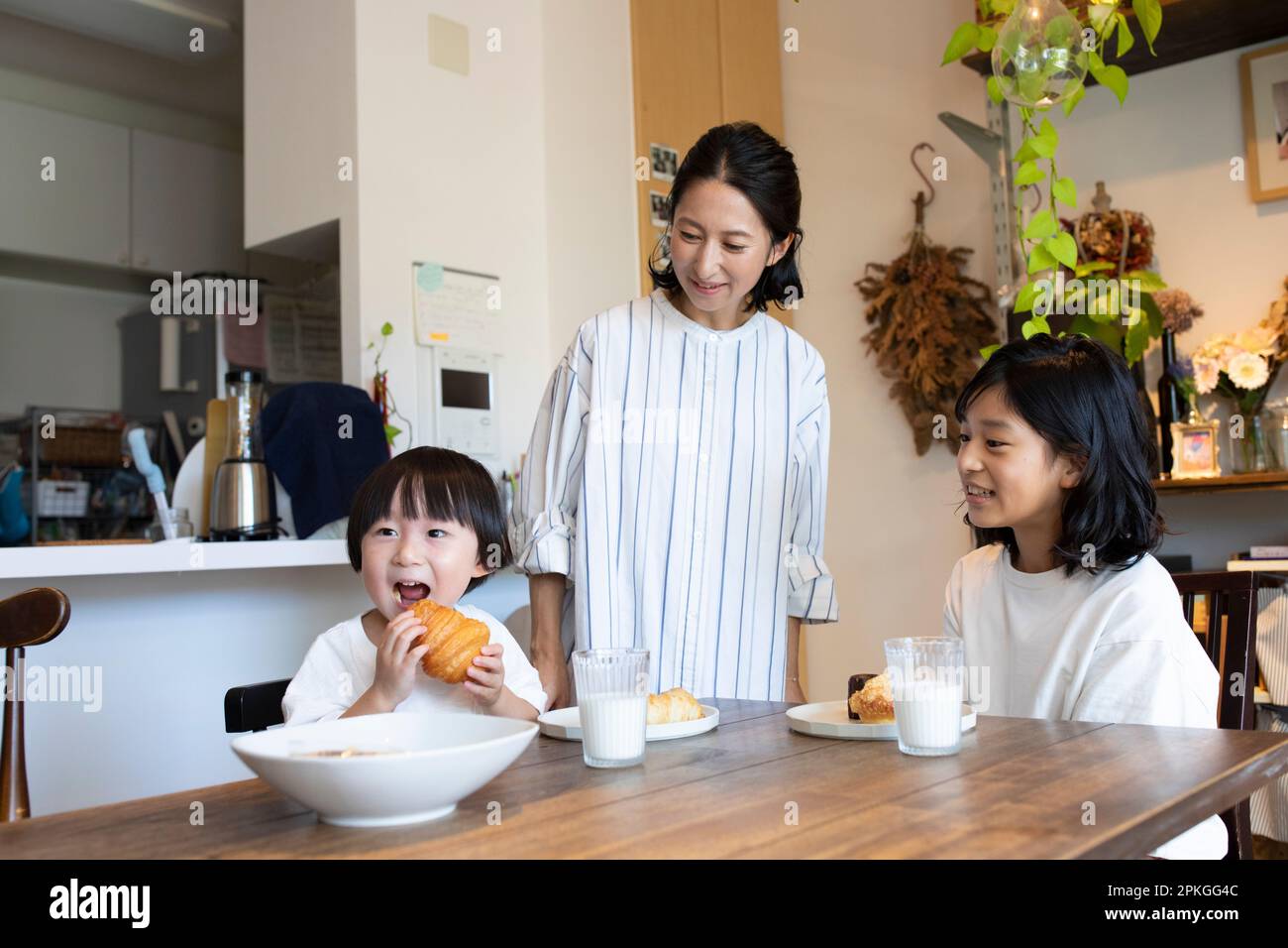 Boy eating bread with his mother and sister Stock Photo - Alamy