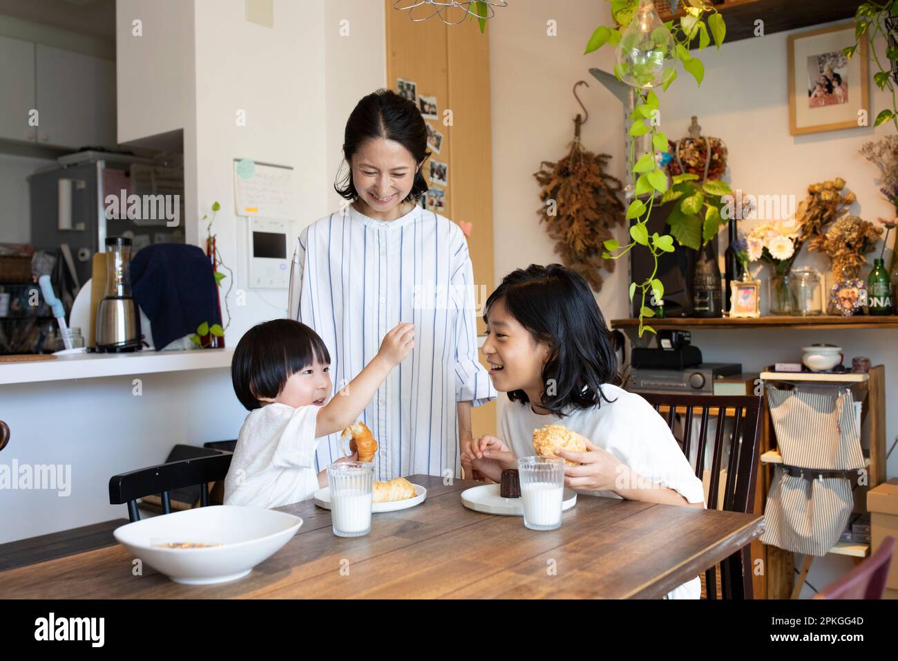 Children eating a snack with their mother Stock Photo - Alamy
