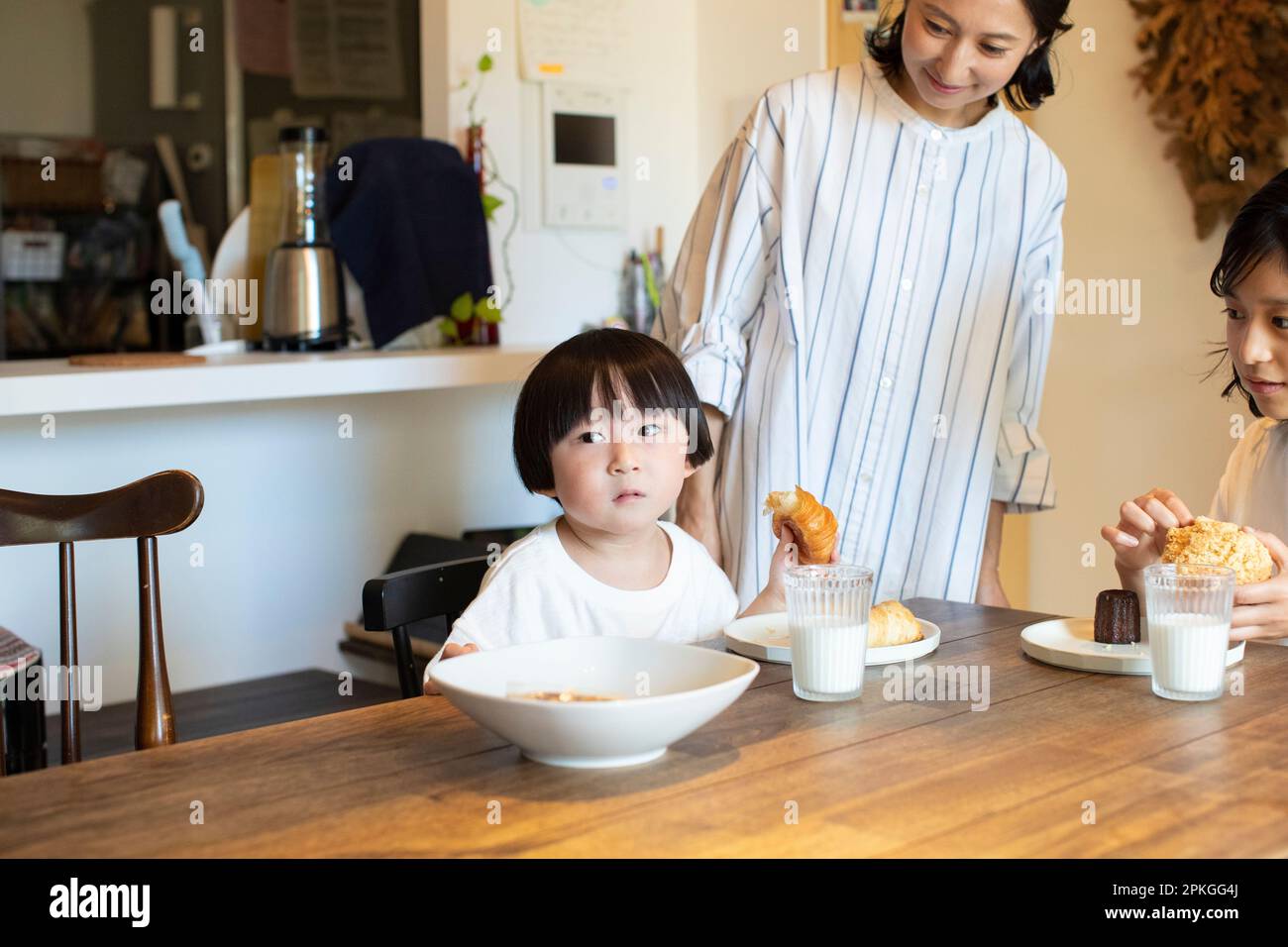 Children eating a snack with their mother Stock Photo - Alamy