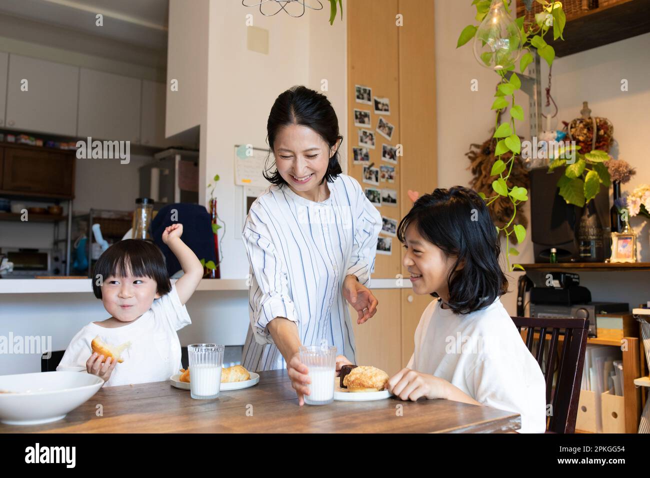 Children eating snacks and mother putting down drinks Stock Photo - Alamy