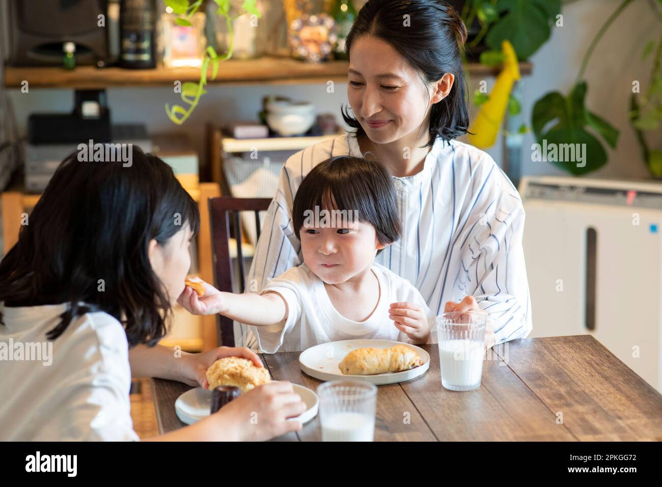 A brother and his mother giving bread to his sister Stock Photo - Alamy