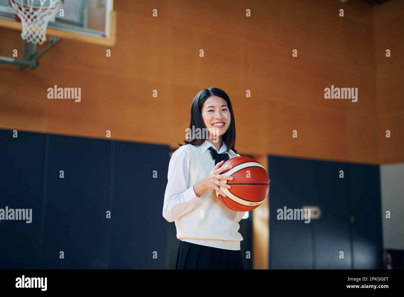 Female high school student with basketball in gymnasium Stock Photo - Alamy