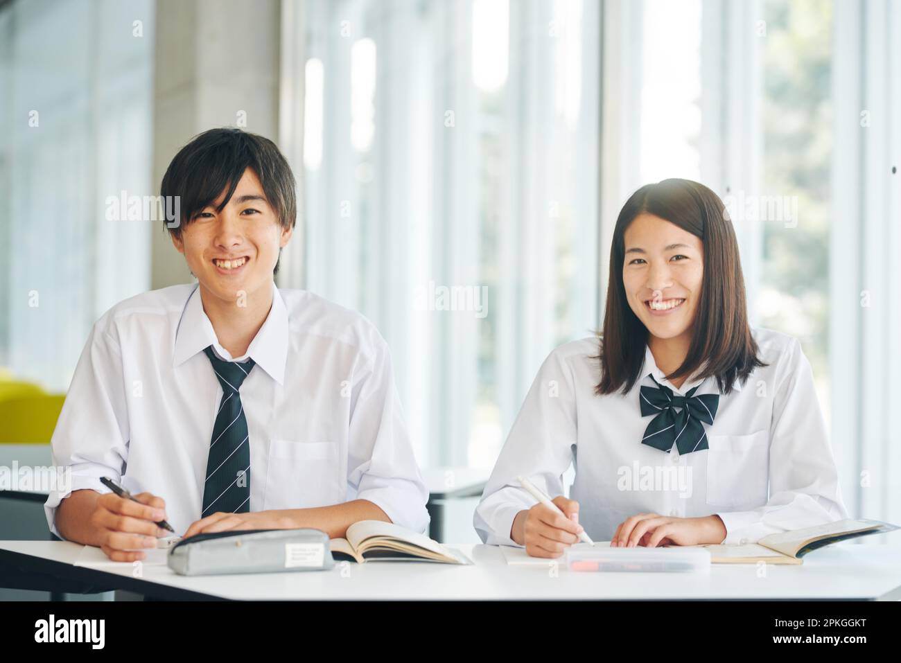 Male and female high school students studying in the study room Stock ...