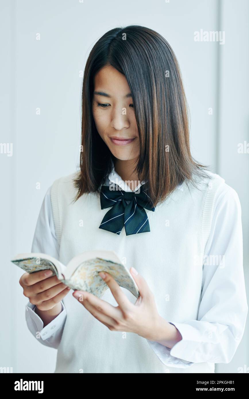 High school girl reading a book by the window Stock Photo - Alamy