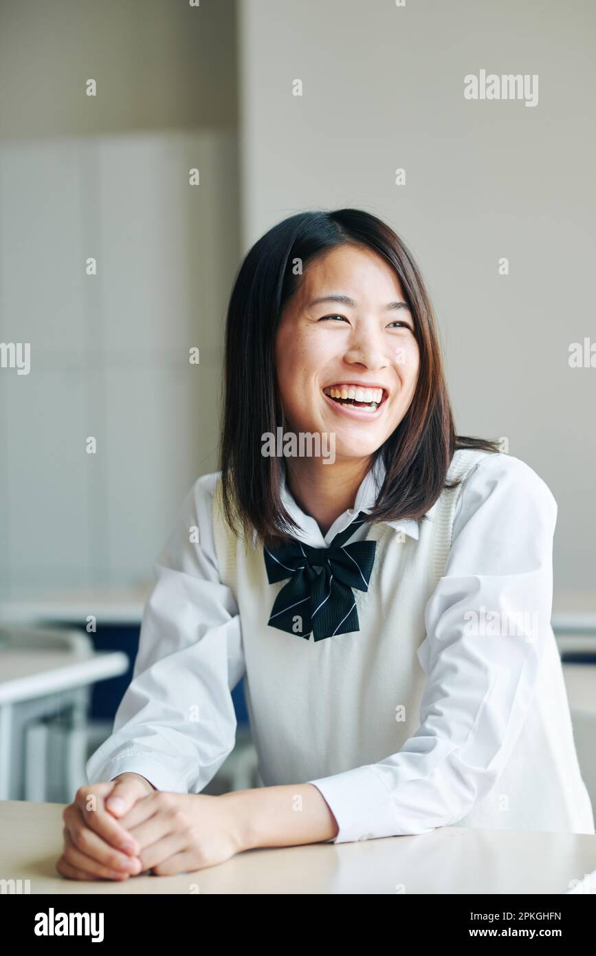 High school girls smiling in a classroom Stock Photo - Alamy