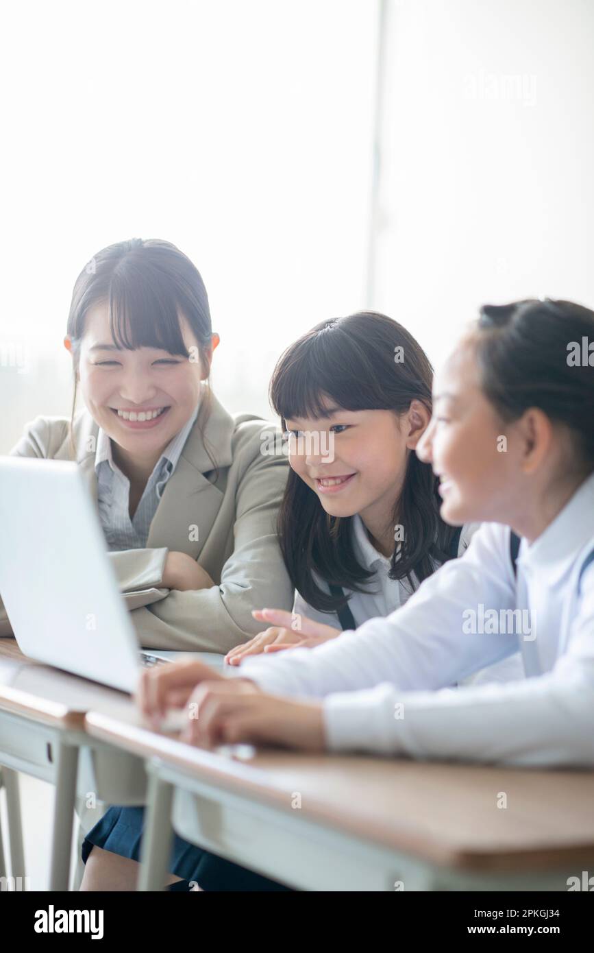 An elementary school student learning programming from his teacher ... An elementary school student learning programming from his teacher ...