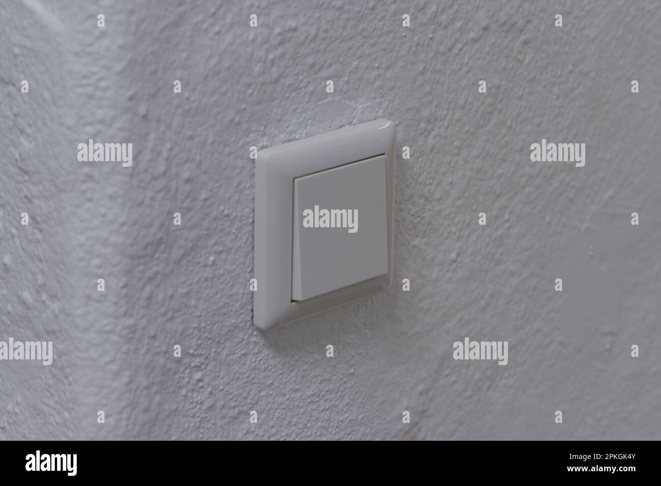 a light switch, a plastic mechanical switch of white color installed on ...