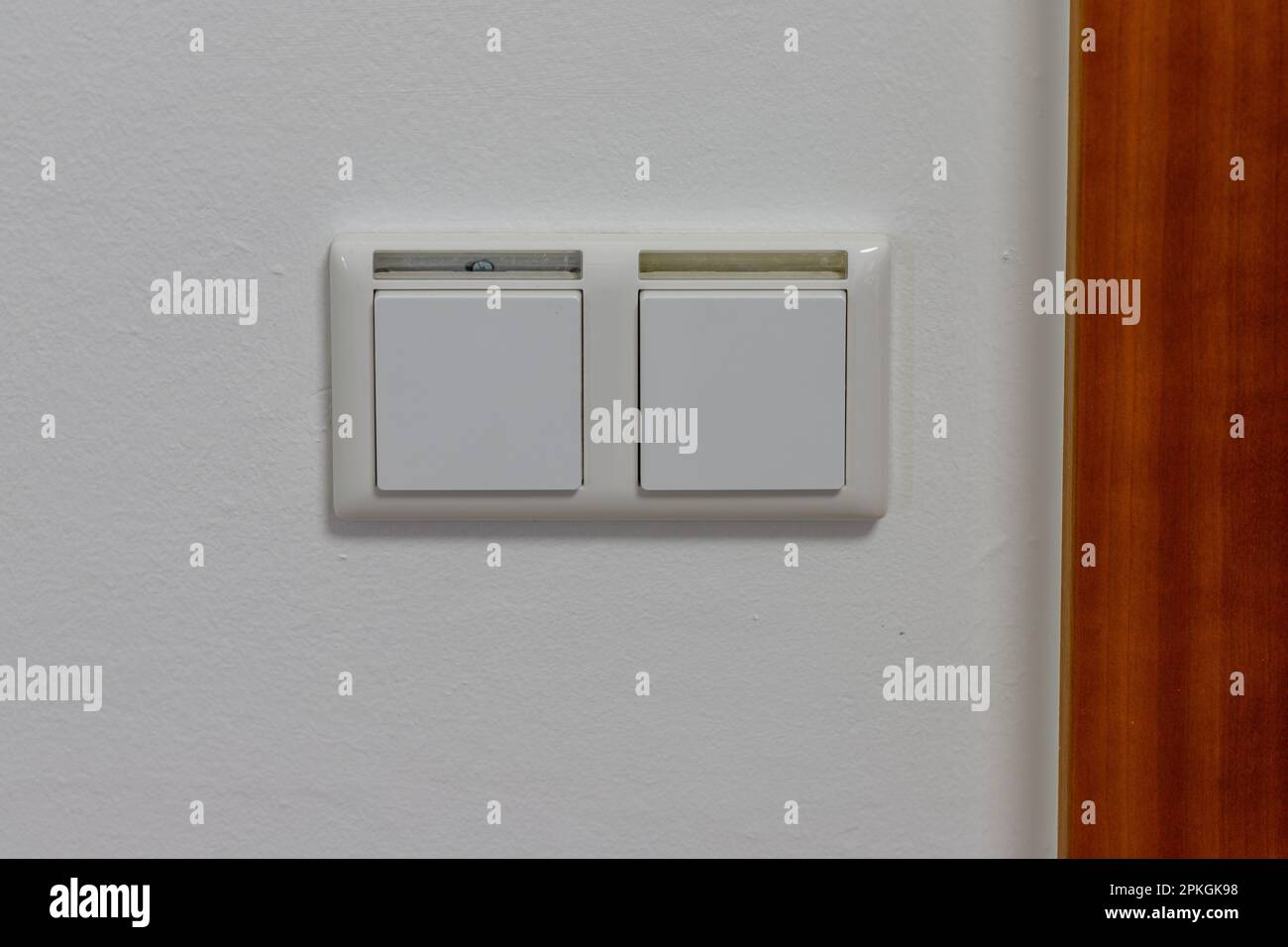 a light switch, a plastic mechanical switch of white color installed on ...