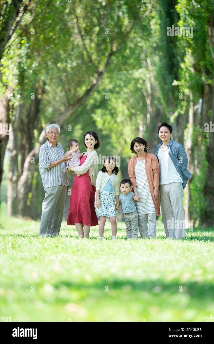 Family of three generations smiling at a row of poplar trees Stock ...