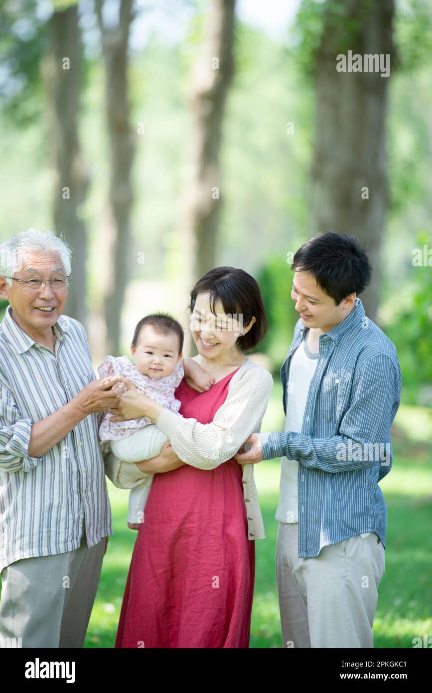 A family of three generations chatting in a row of poplar trees Stock ...