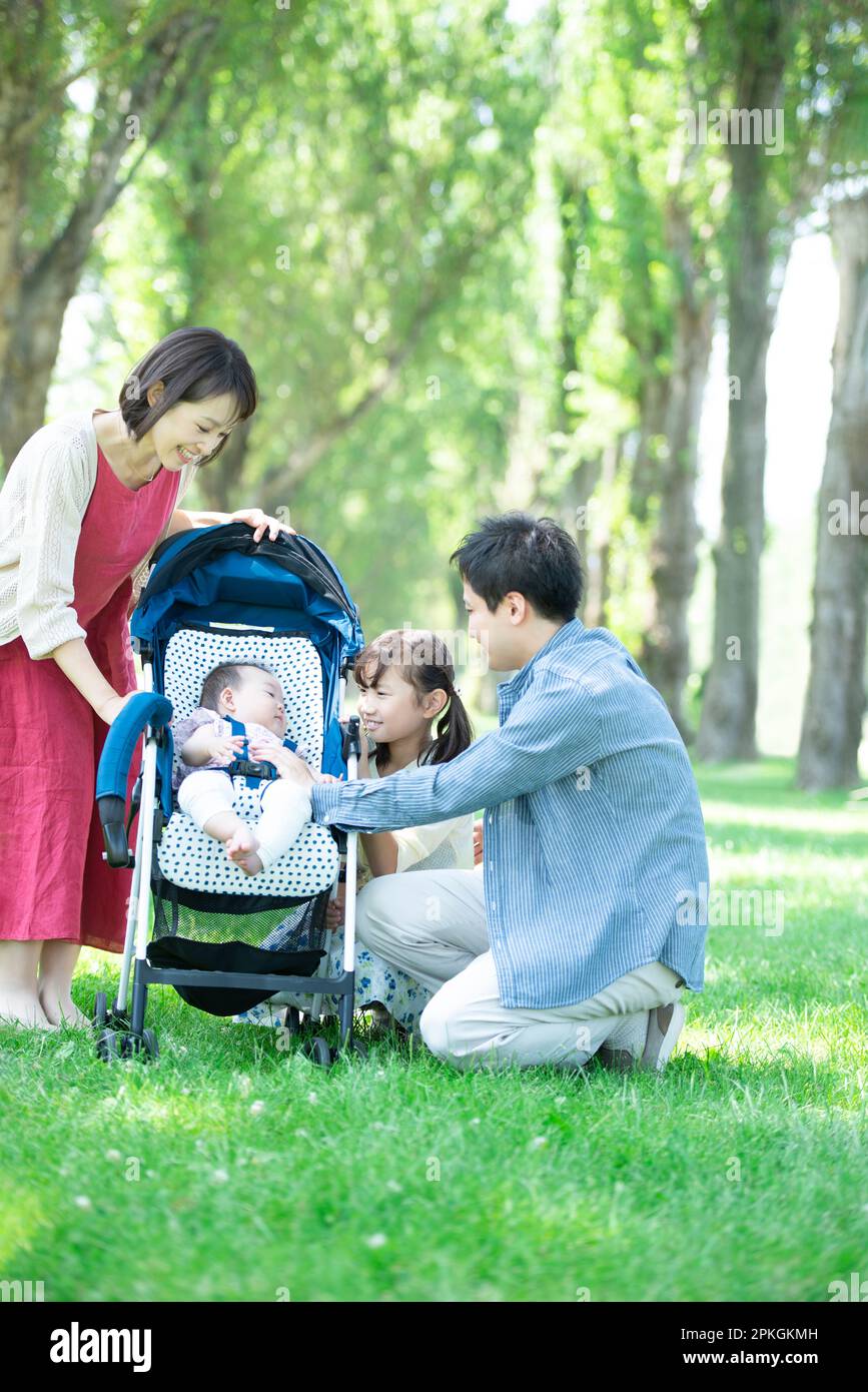 Parent and child watching baby in stroller Stock Photo - Alamy
