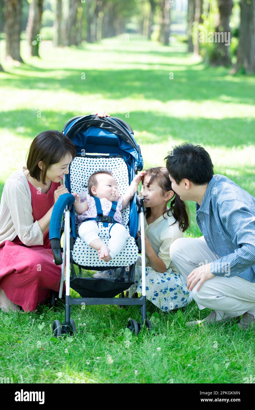 Parent and child watching baby in stroller Stock Photo - Alamy