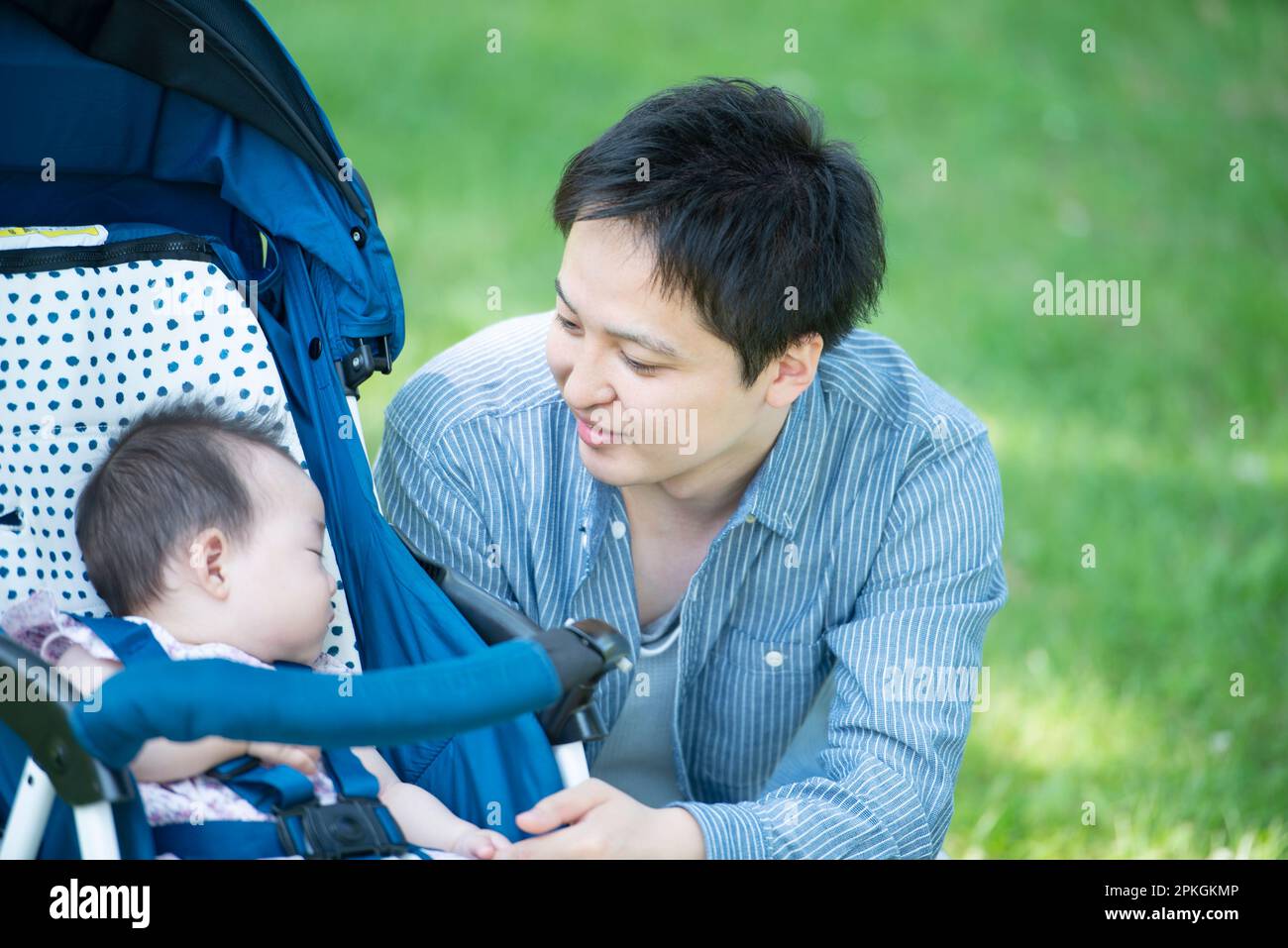 A father watching his baby in a stroller Stock Photo - Alamy