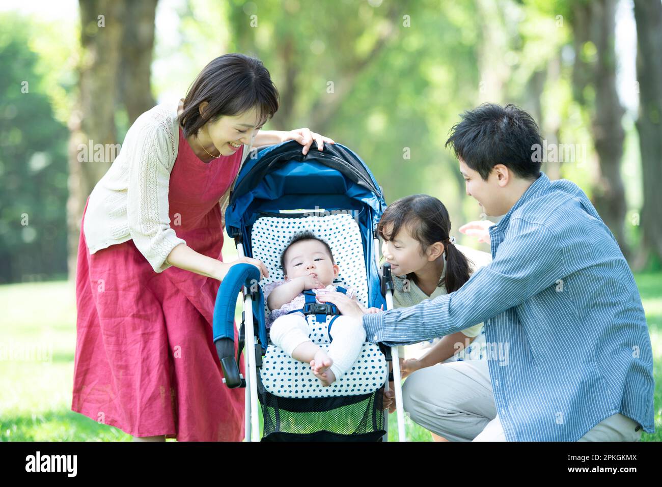 Parent and child watching baby in stroller Stock Photo - Alamy