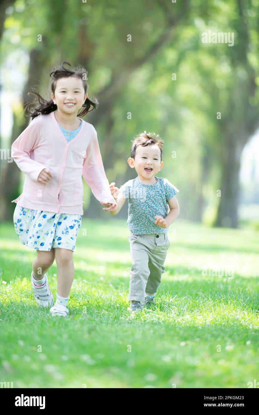 Sister and brother running alongside poplar trees Stock Photo - Alamy