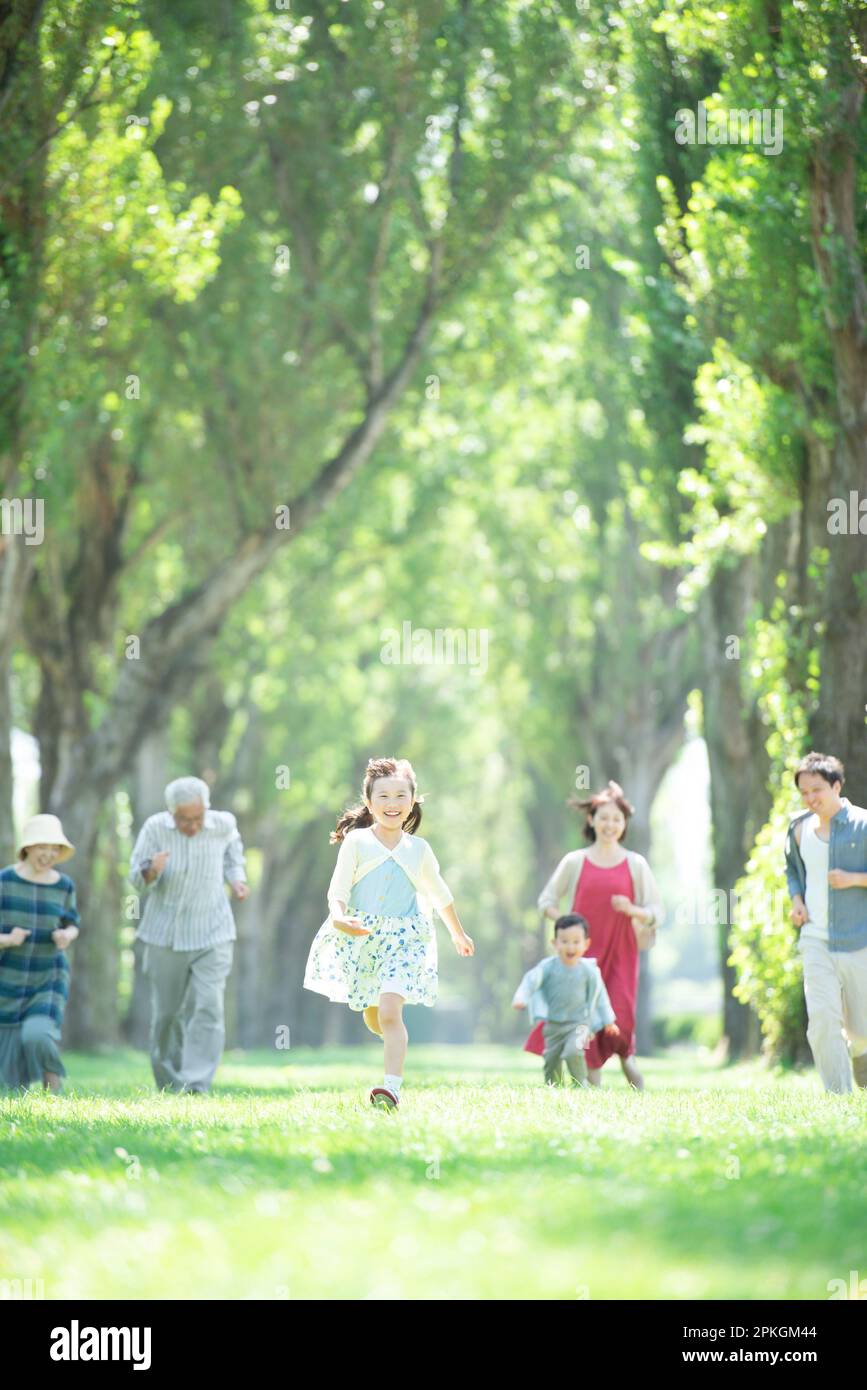 Family of 3 generations running alongside poplar trees Stock Photo - Alamy
