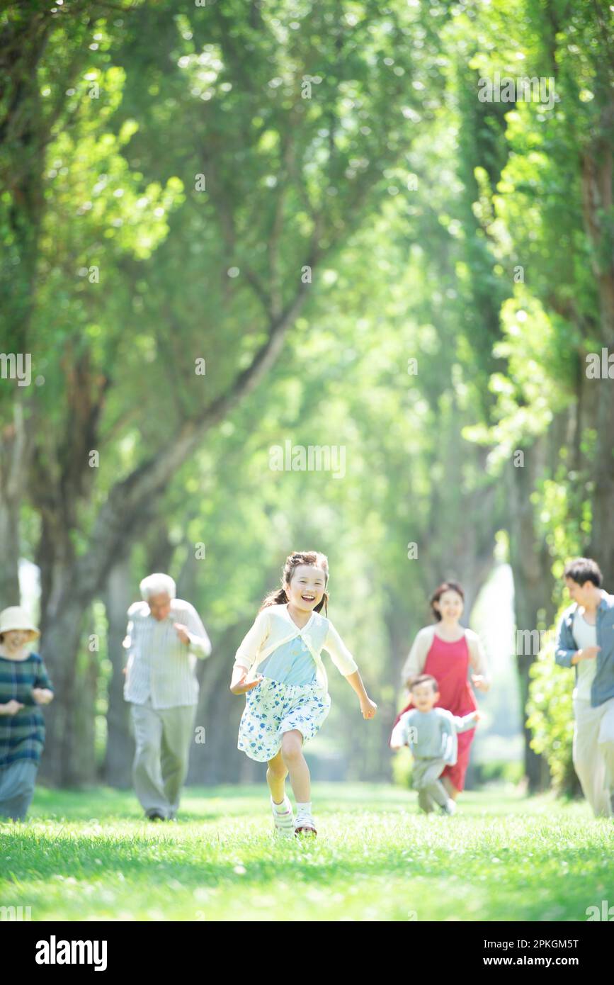 Family of 3 generations running alongside poplar trees Stock Photo - Alamy
