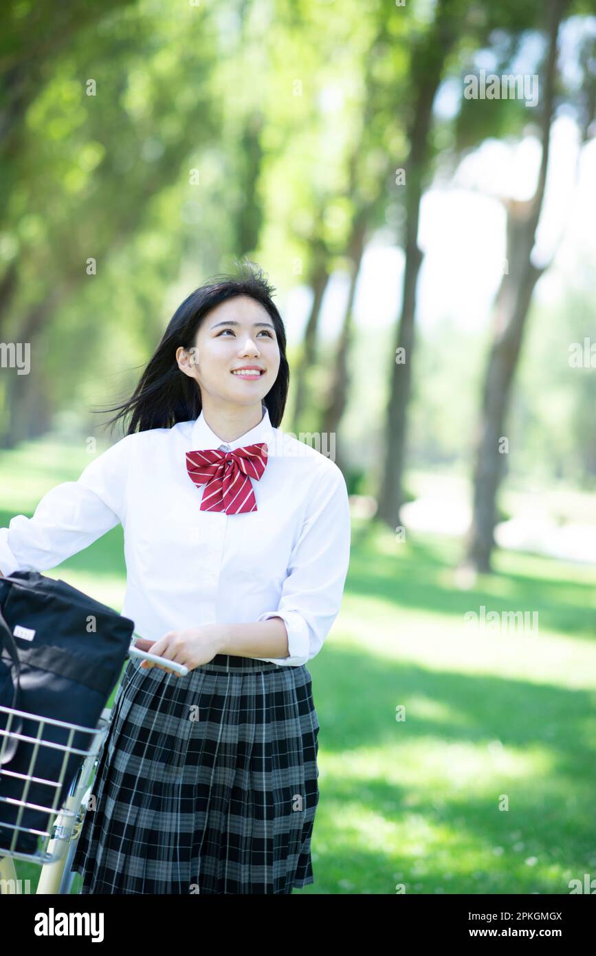 Female student pushing a bicycle on poplar trees Stock Photo - Alamy