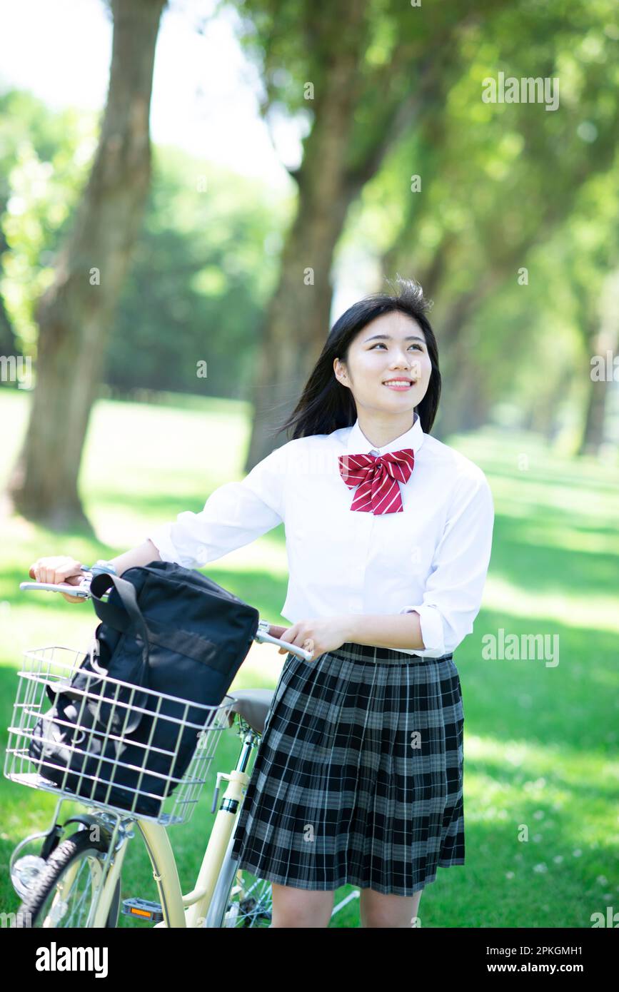 Female student pushing a bicycle along poplar trees Stock Photo - Alamy