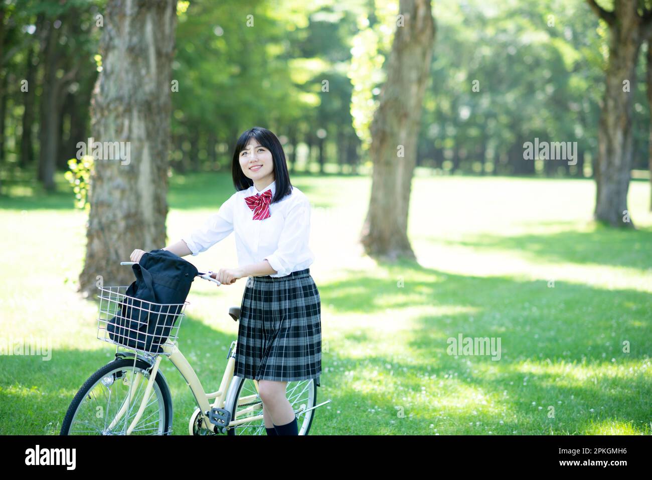 Female student pushing a bicycle along poplar trees Stock Photo - Alamy