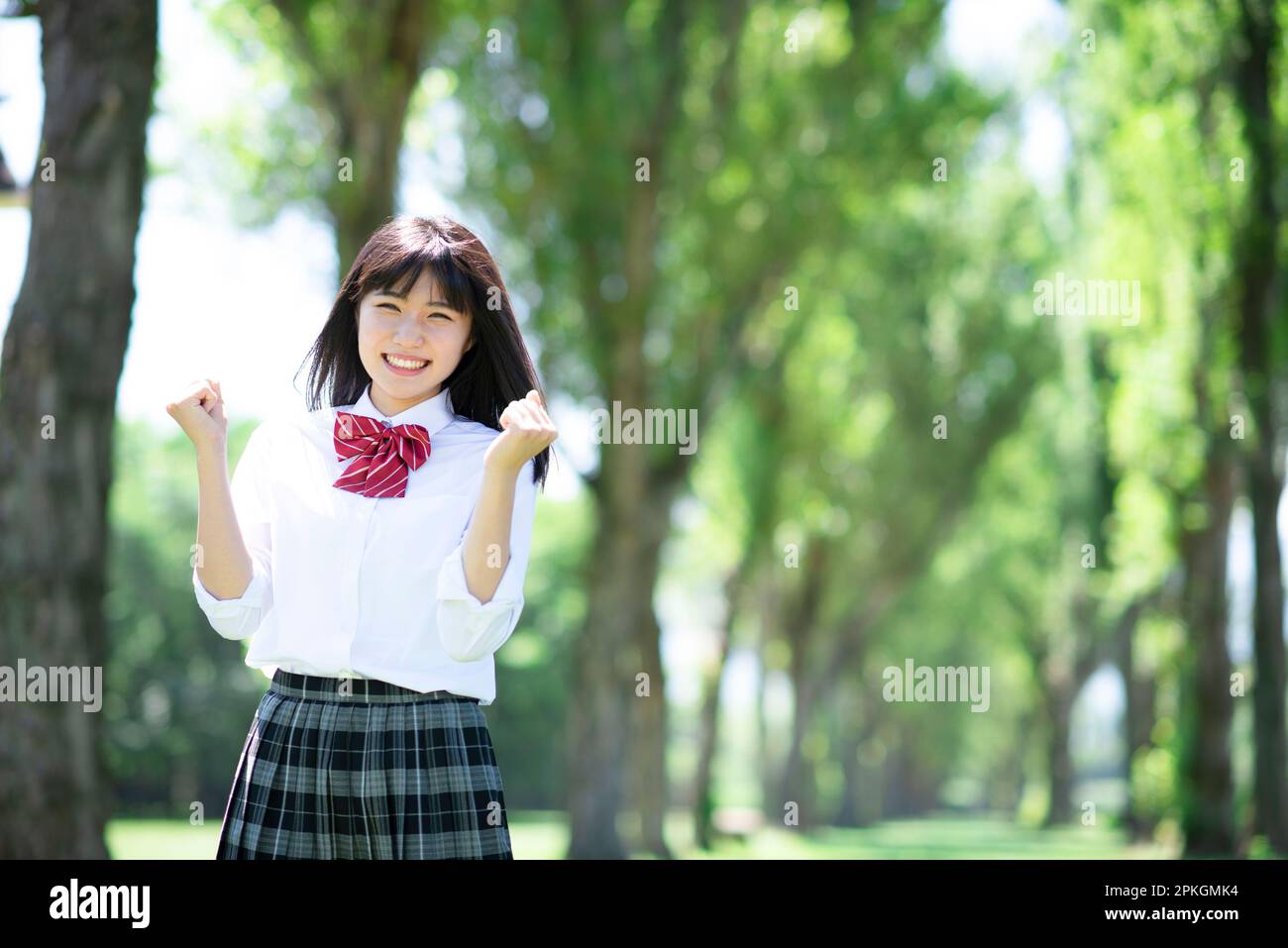 Female student posing her guts at a row of poplar trees Stock Photo - Alamy