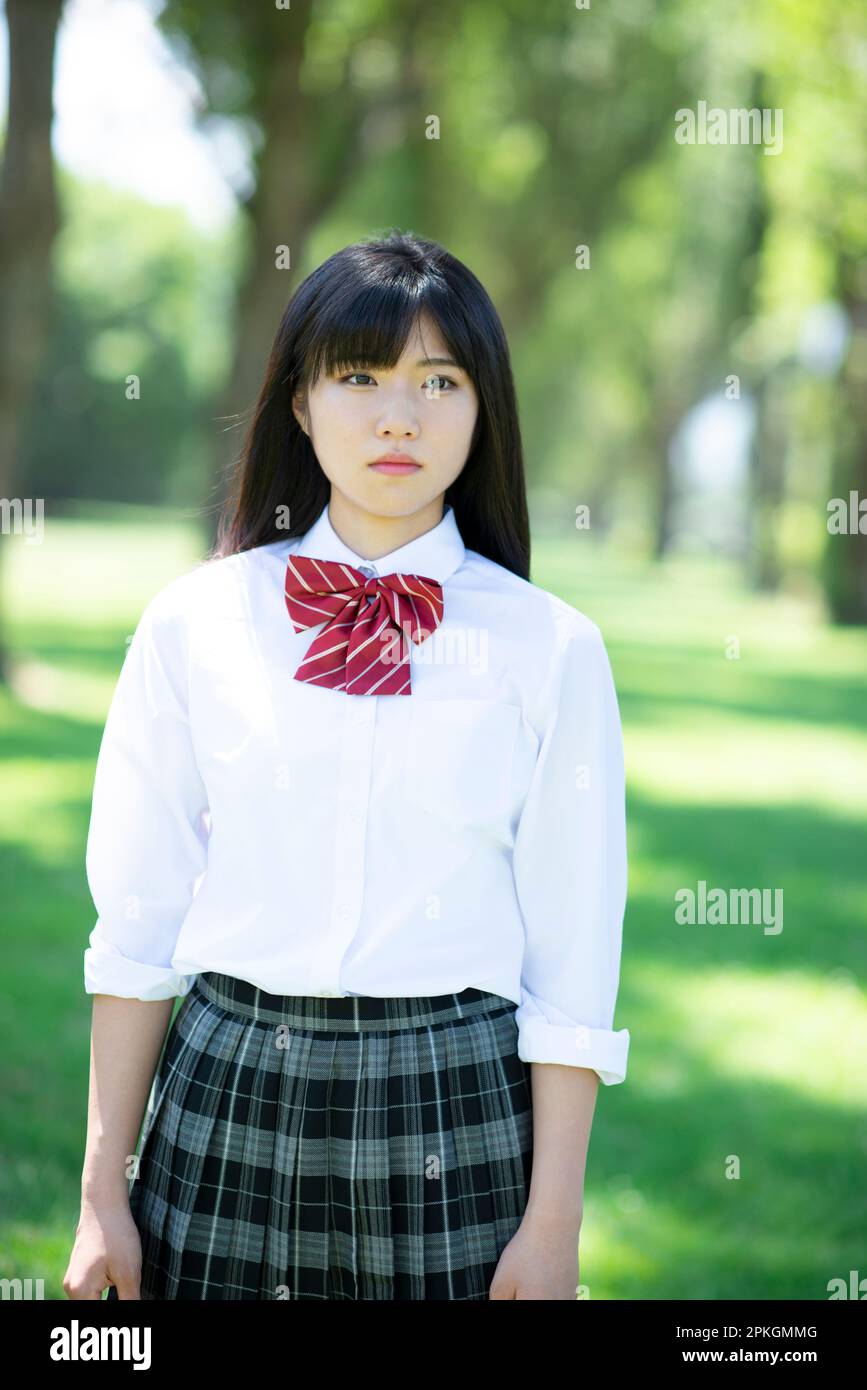 A female student making a serious face at a row of poplar trees Stock ...