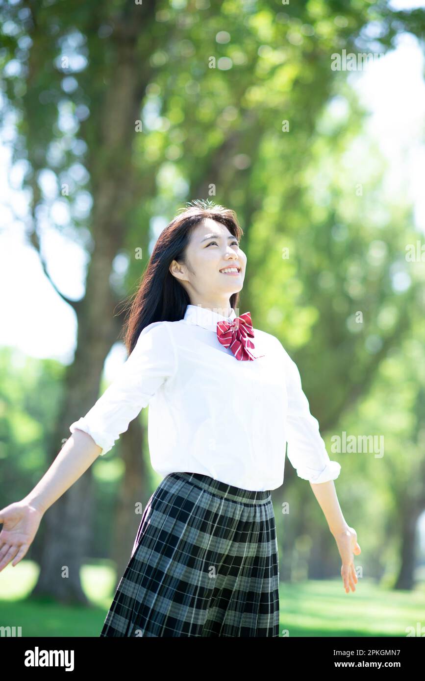 Female student taking a deep breath at a row of poplar trees Stock ...