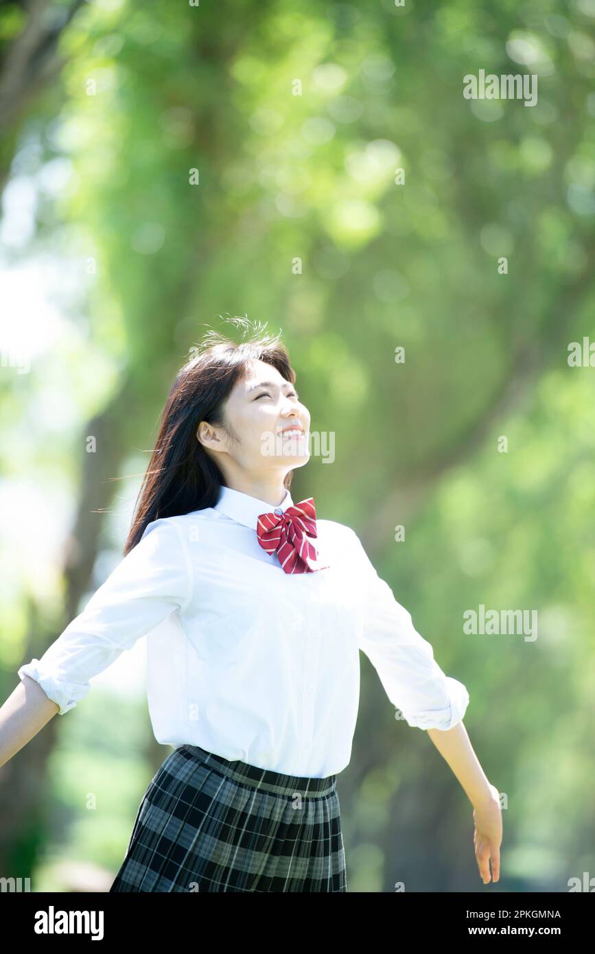 Female student taking a deep breath at a row of poplar trees Stock ...