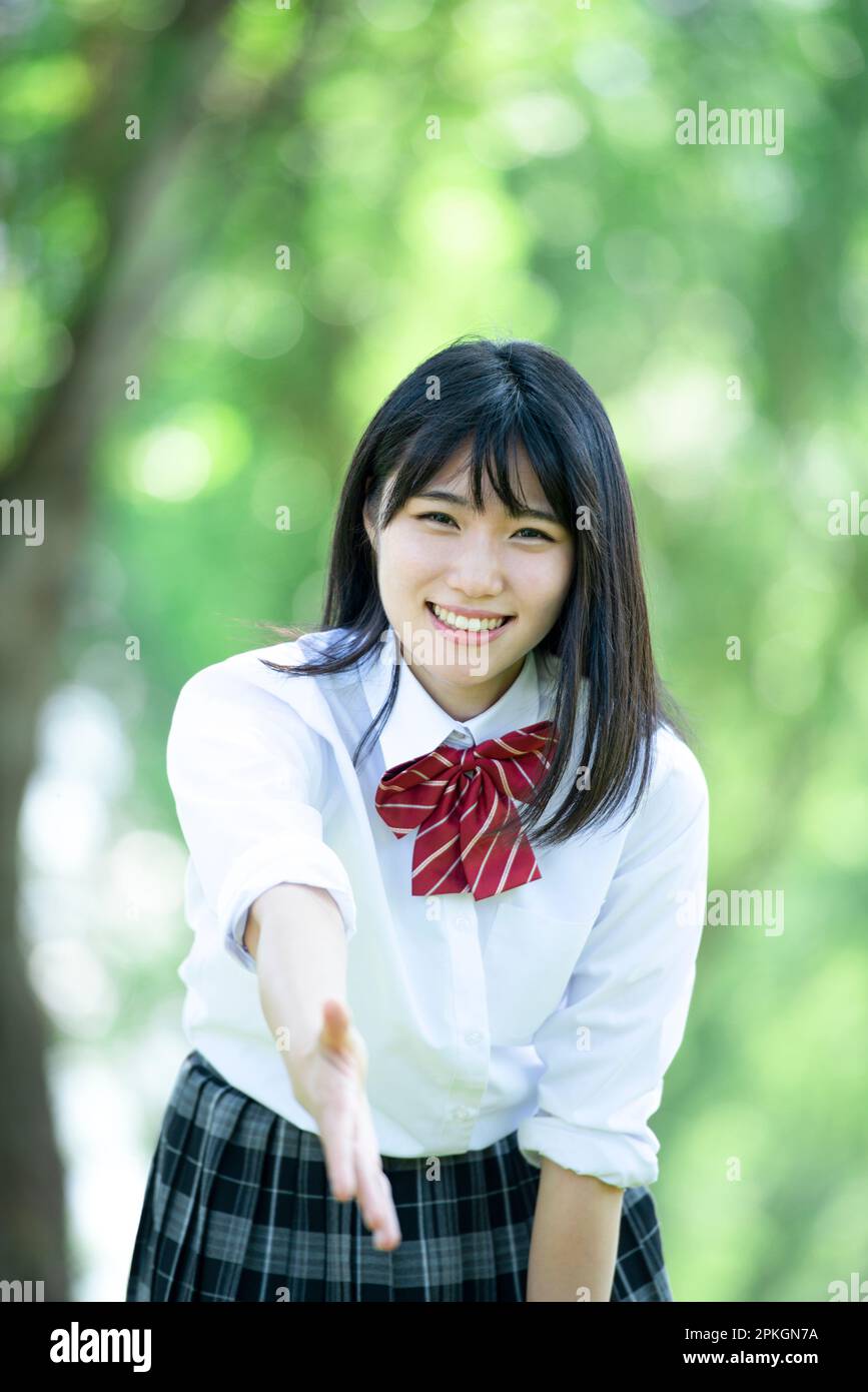 Female student holding out her hand at a row of poplar trees Stock ...
