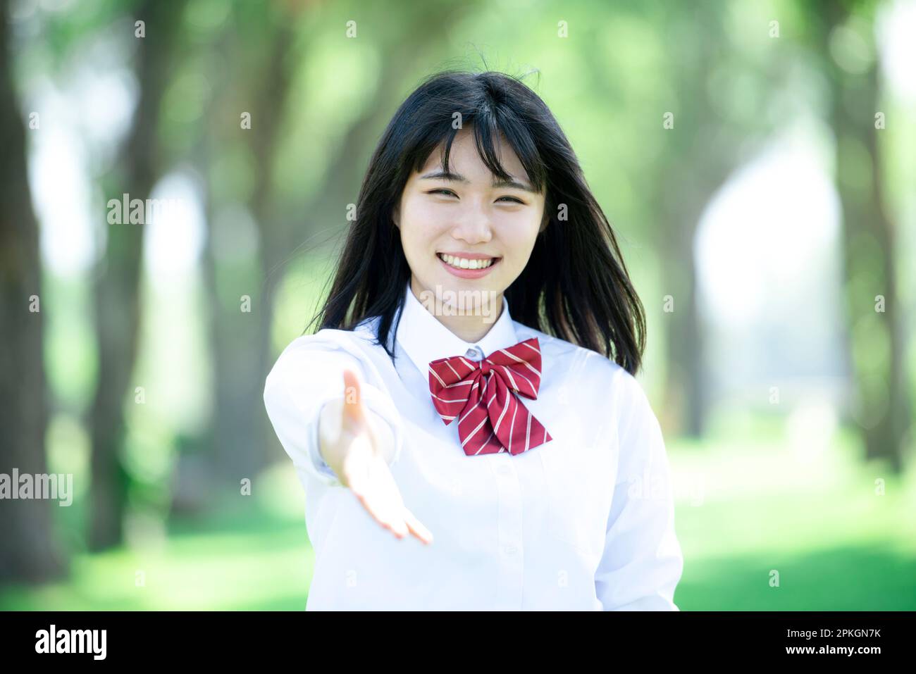 Female student holding out her hand at a row of poplar trees Stock ...