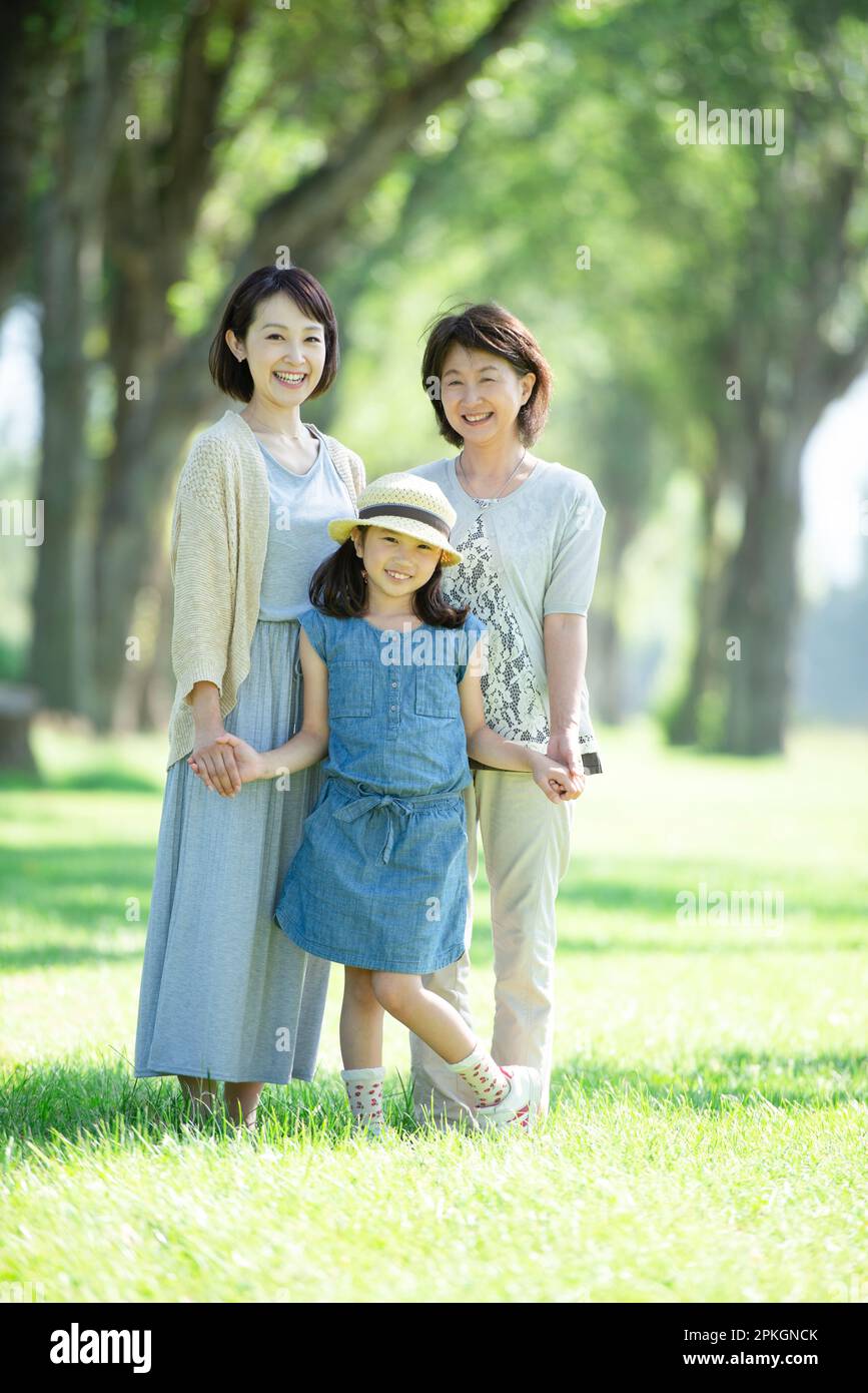Family of three generations smiling at a row of poplar trees Stock ...