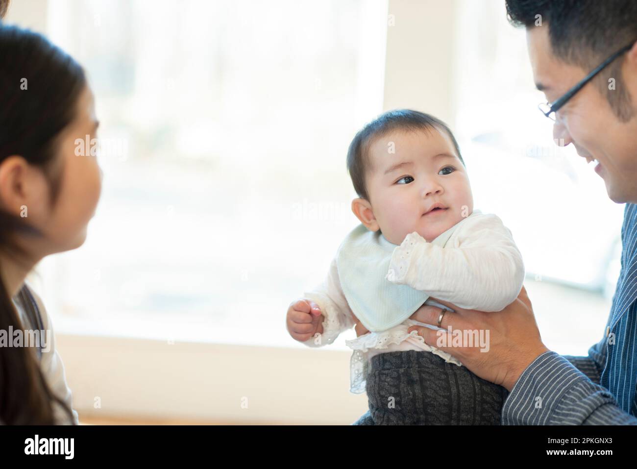 Family smiling around baby Stock Photo - Alamy