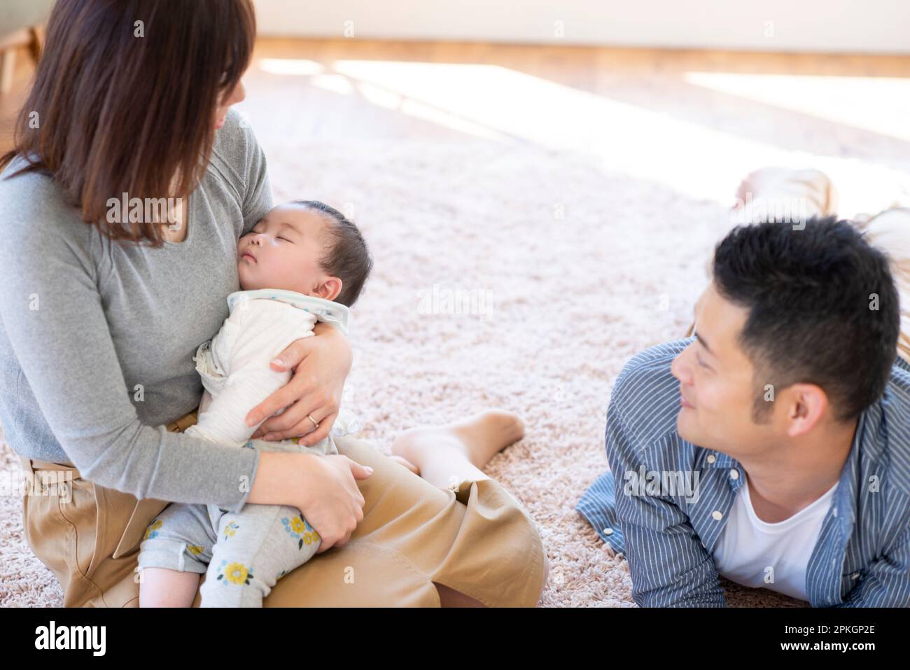Family watching sleeping baby Stock Photo - Alamy