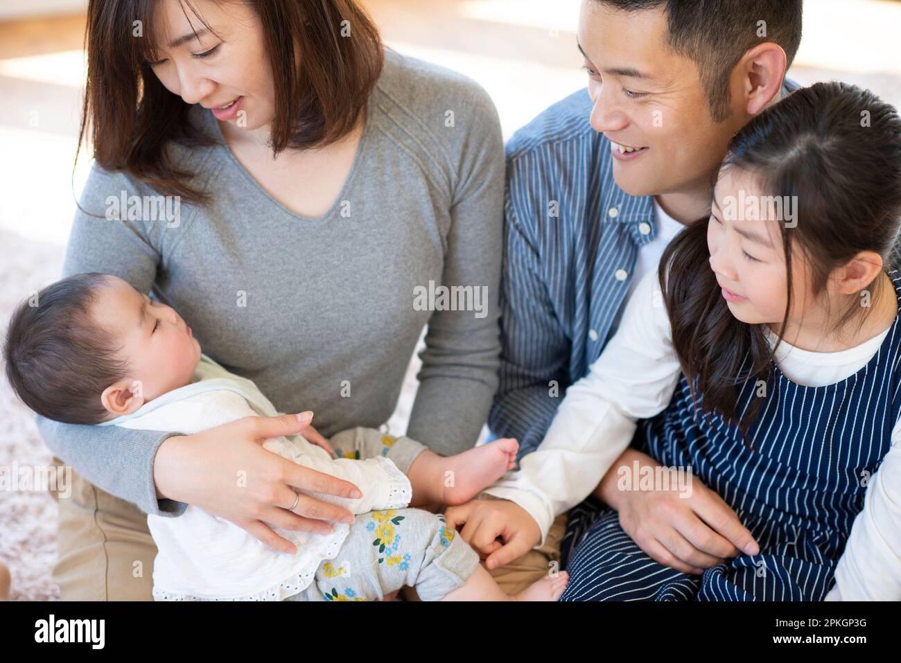 Family watching over baby Stock Photo - Alamy
