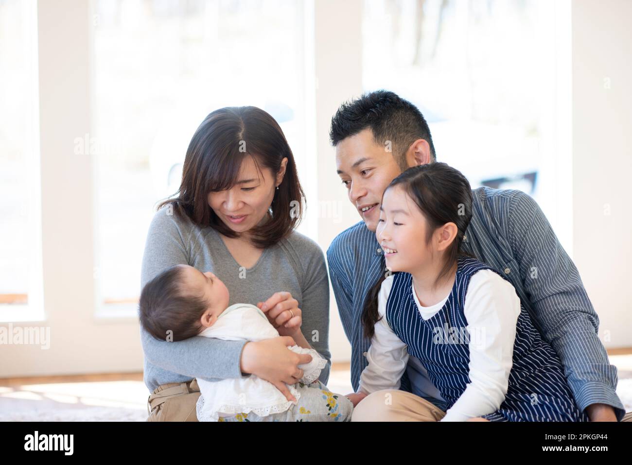 Family watching baby Stock Photo - Alamy
