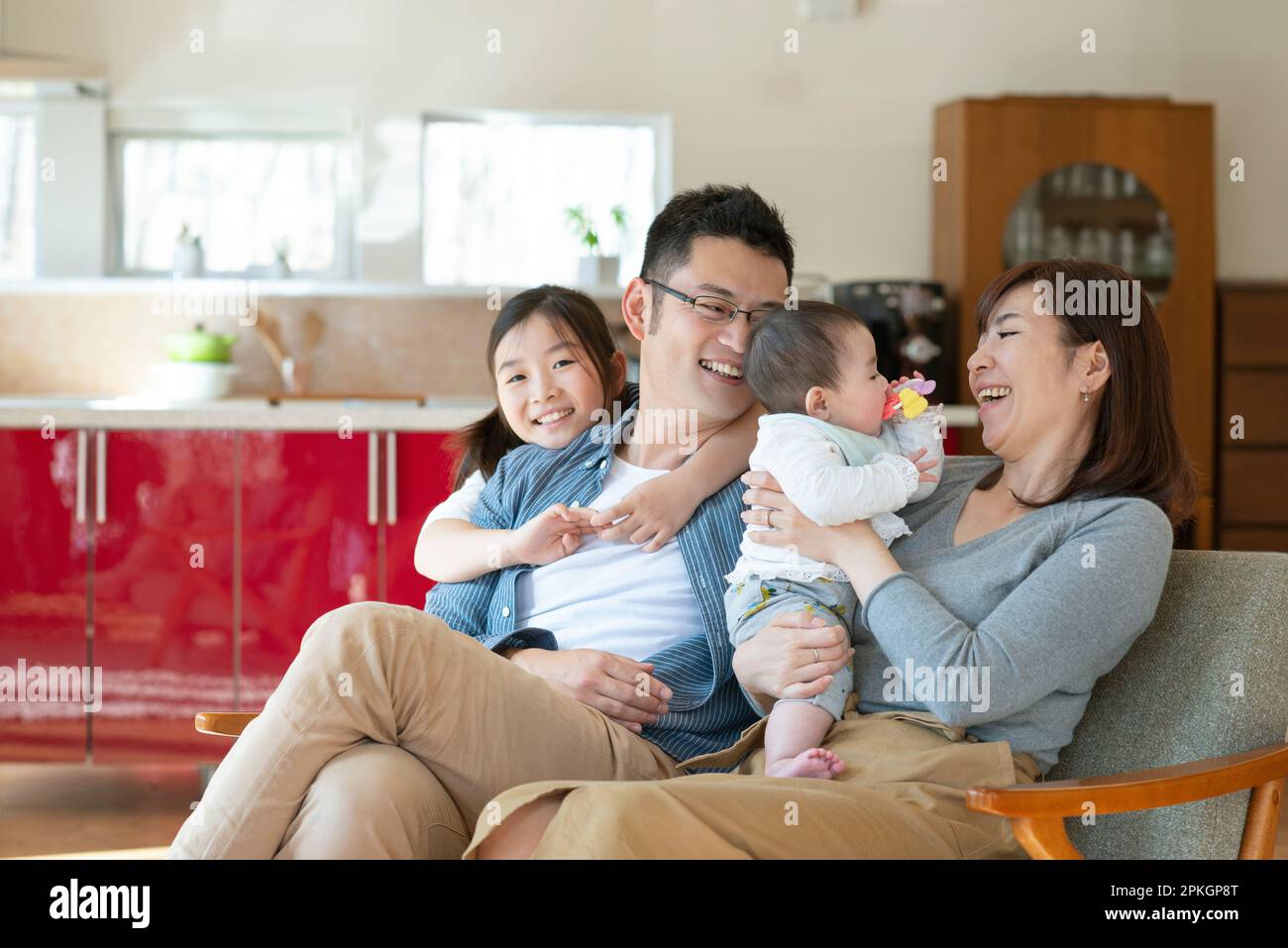 Family sitting on the couch chatting Stock Photo - Alamy